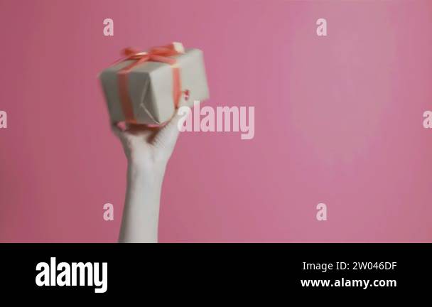 young girl raised her hands up holding a wrapped gift and moves, a ...