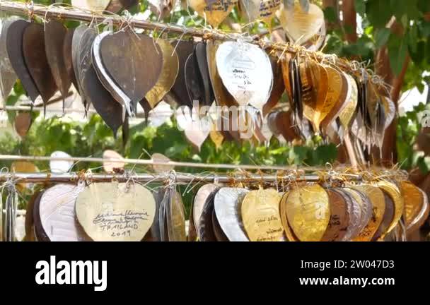 Metal leaves with wishes near temple. Rack with traditional metal ...