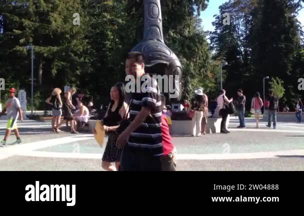People playing fountain water beside Vancouver aquarium totem Stock ...