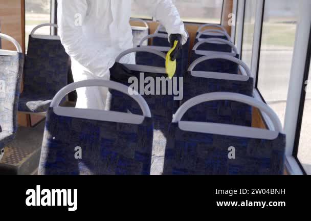 Hazmat team worker disinfects bus interior with antibacterial sanitizer ...