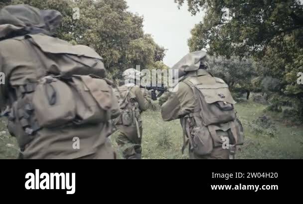 Squad of fully armed commando soldiers during combat in a forest ...