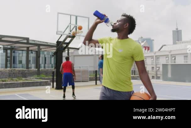 Front view of African american basketball player drinking water in ...