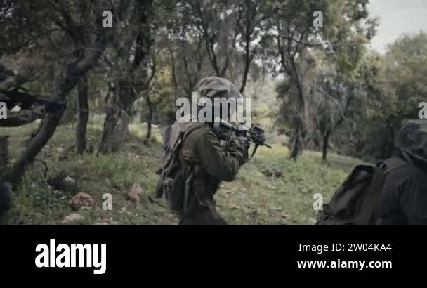 Squad of fully armed commando soldiers during combat in a forest ...