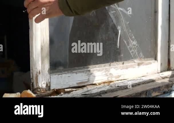 Mens hands pull out a glass window from the frame. Dismantle the frames ...