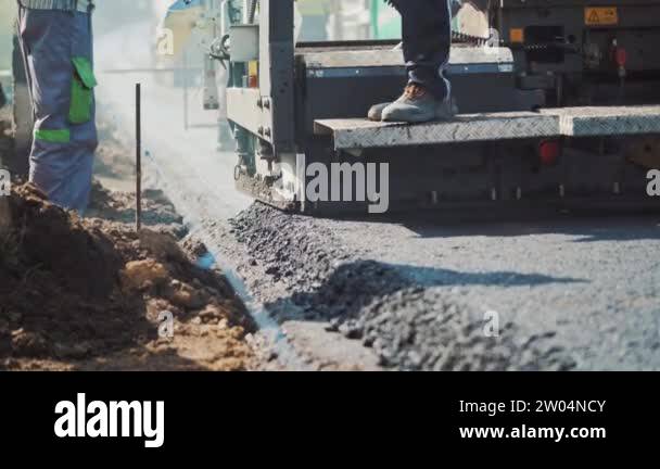Asphalt paver machine laying hot asphalt to the road and workers ...