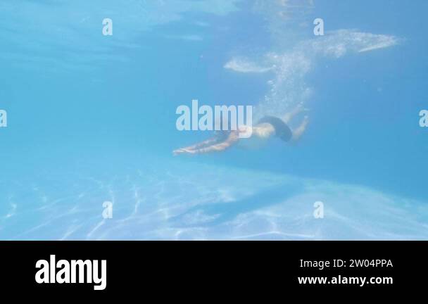 Athlete man jumping in blue water of swimming pool underwater view. Man ...