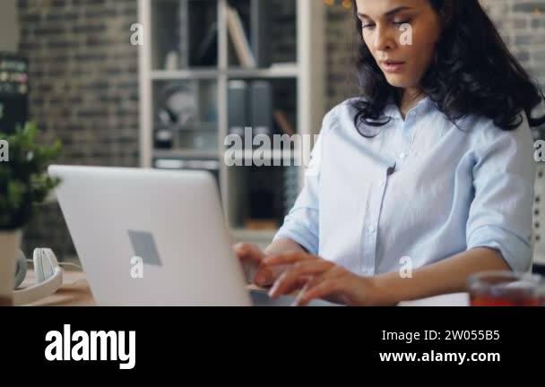 Portrait of tired young lady typing with laptop and yawning in workplace Stock Video Footage - Alamy
