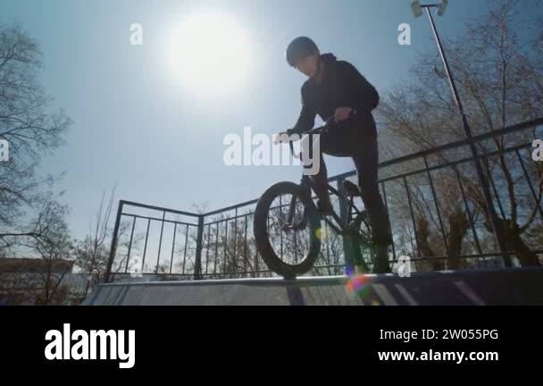 An alone bmx rider in black hoodie on ramps in the skatepark Stock ...