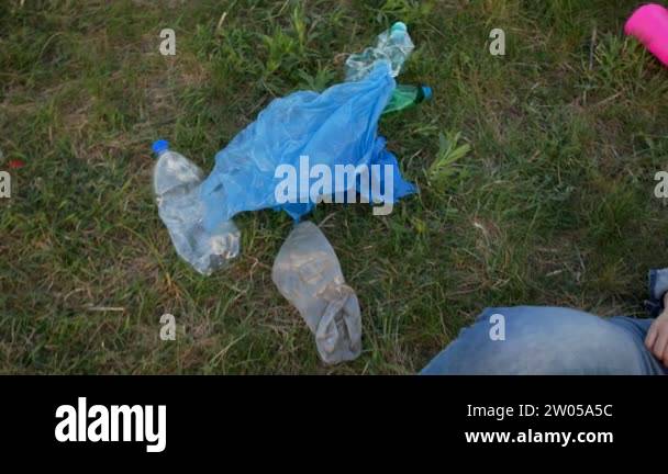 Sad girl lying covering his eyes on the garbage filled grass - plastic ...