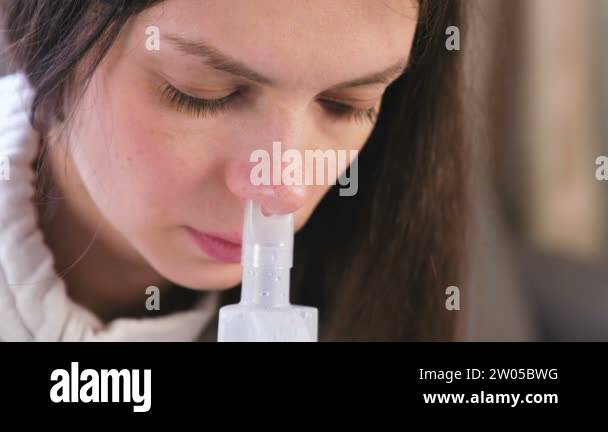 Use nebulizer and inhaler for the treatment. Young woman inhaling ...