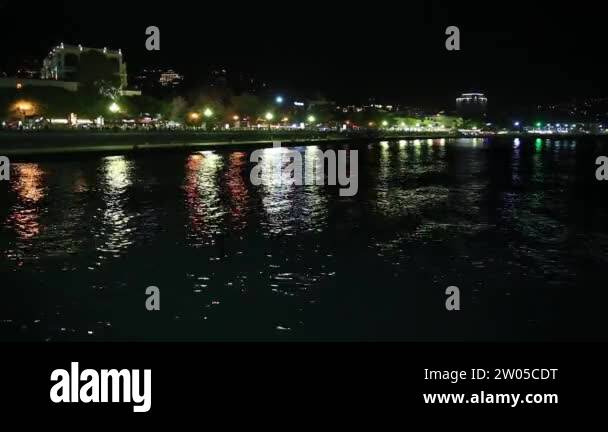 Panorama view of Yalta town from the Black sea. Night life on ...