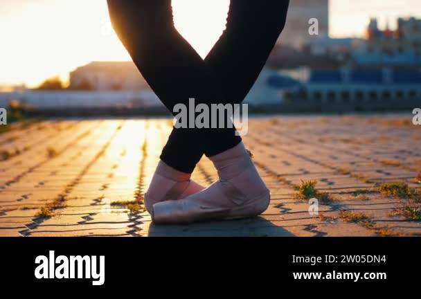 Young attractive ballerina in ballet poses on the tiptoe and dances ...
