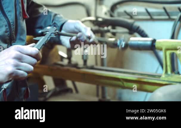 A mechanic in working form and gloves measures height, width and length ...