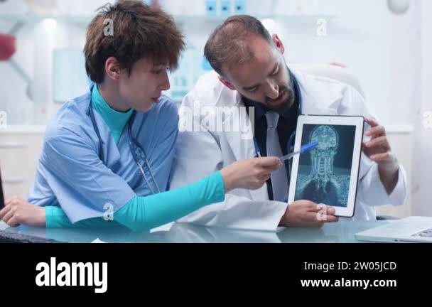 Doctor and young nurse looking at a MRI CT X ray scan on a digital ...