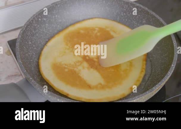 The plastic green spatula overturns the traditional Russian pancake in ...