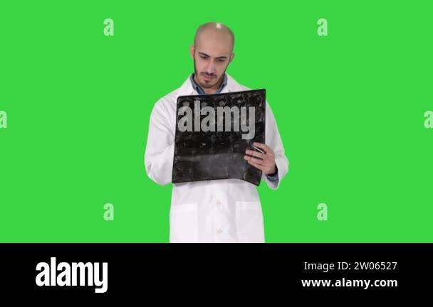 Doctor reviewing shoulder x-ray scan while walking on a Green Screen ...