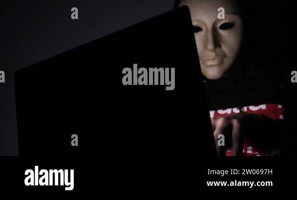Male hacker hidden face with the mask accessing to personal information ...