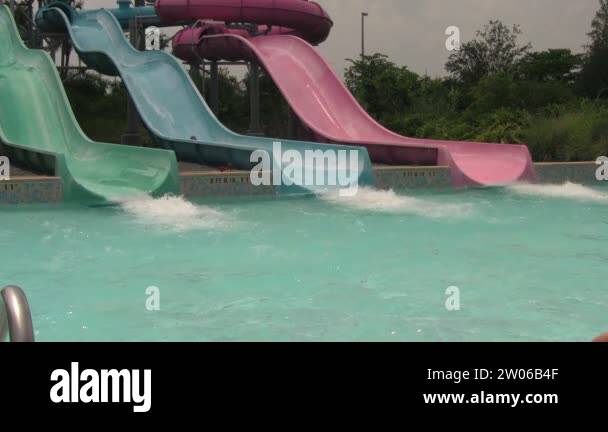 Guests on Inflatable Tubes at a Water Park Ending a Water Slide Ride ...