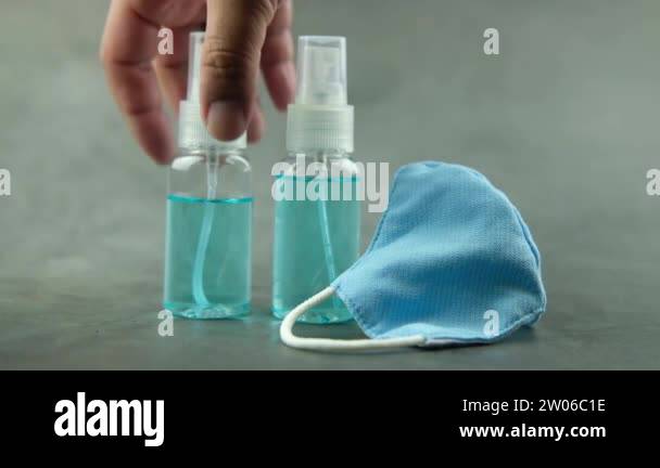 Man hand use alcohol spray cleaning of mask. Two alcohol spray bottle ...