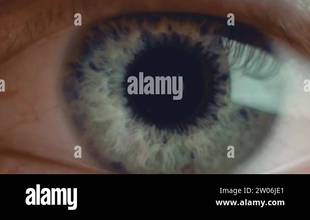 Extra macro shot of mans opening eye with blue iris and big pupil ...
