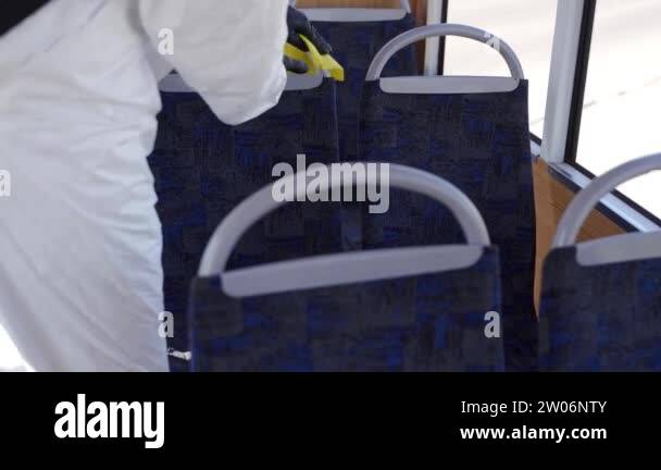 Hazmat team worker disinfects bus interior with antibacterial sanitizer ...