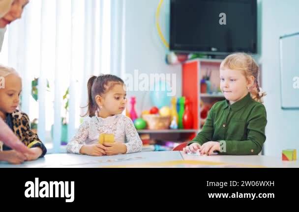 Little girls during the lesson on the classroom background with TV ...