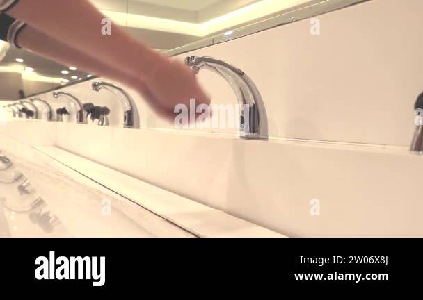 Contactless hand washing at the mall. Hand washing in a public toilet ...