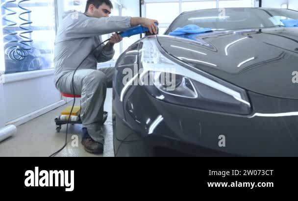 Employee is a professional who polishes a black car, repairs cars ...