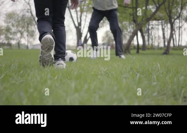 Little boy playing football with his father or grandfather close-up ...