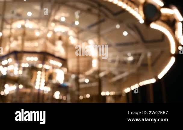 Illuminated blurred merry go round in park. Brightly illuminated ...