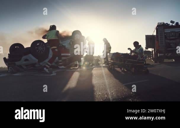 On the Car Crash Traffic Accident Scene: Paramedics Giving First Aid ...