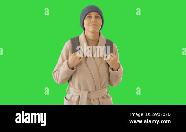 Young woman wearing coat and backpack walking on a Green Screen, Chroma ...
