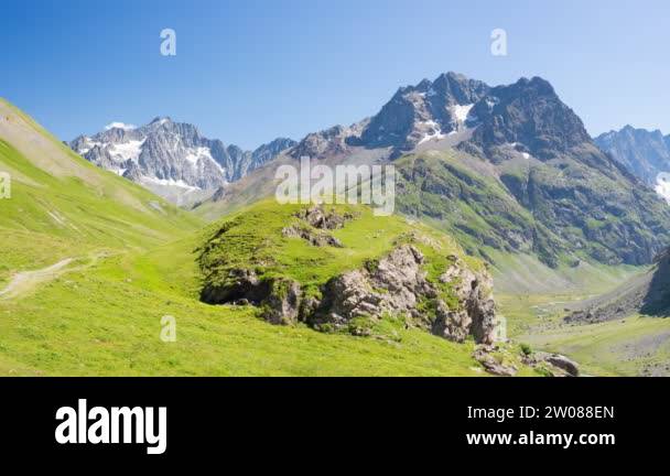 Panorama of high altitude mountain peaks in the Alps, green valleys and ...
