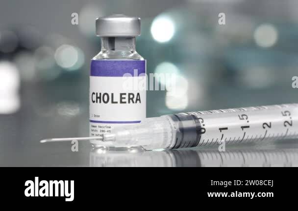 Cholera vaccine vial in medial lab with syringe placed next to it while ...