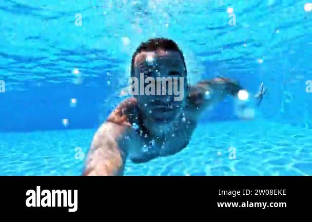 Man swims with underwater camera inside the swimming pool. Transparent ...
