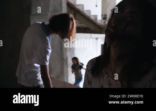 Zombies standing on the floor. A survived woman walking on stairs and ...