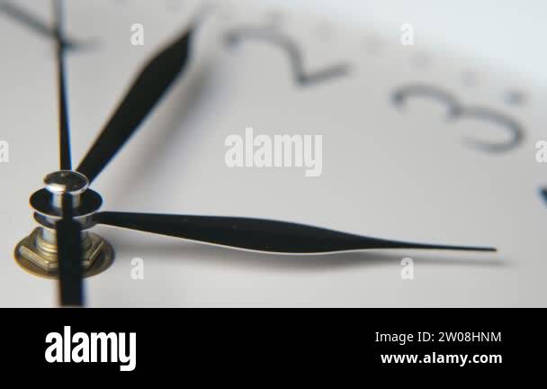 Old-looking white clock face put aslant showing twenty-five minutes ...