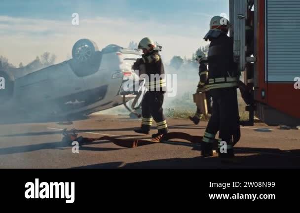 Rescue Team of Firefighters Arrive at the Crash, Catastrophe, Fire Site ...