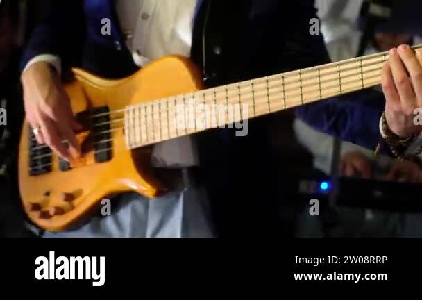 young man in a blue suit, white shirt and grey trousers plays a yellow ...