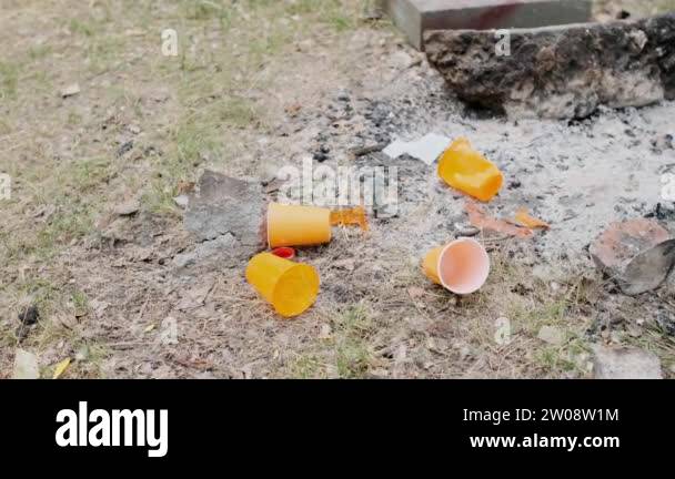 rude man throws down orange plastic cup. plastic pollution. people ...