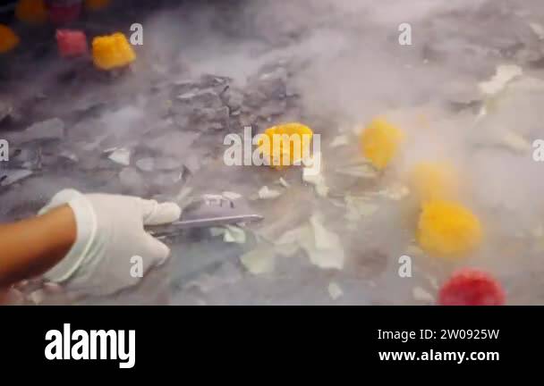 Cooks are taking pieces of cold ice cream on the white steam background ...