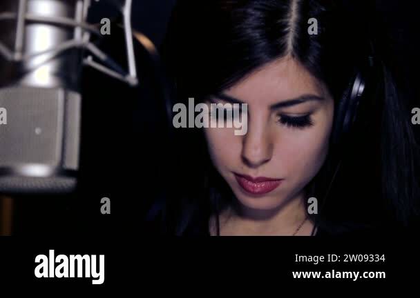 Young beautiful girl sings.Young singer singing into a microphone ...