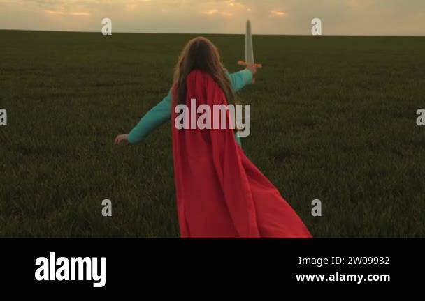 child play knights. girl in a red cloak runs with swords in his hand ...