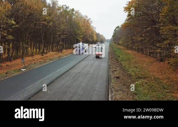 Cars moving on half of asphalt road in autumn. Road repair works on one ...