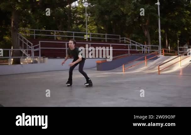 Determinated young man running on inline roller skates at ramp in ...