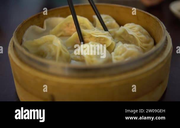 4K Using chopsticks for eating dumplings in a restaurant. Traditional ...