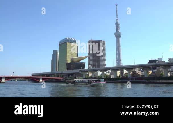 4K Tokyo Skytree building near to river with tourist ship travel. The ...