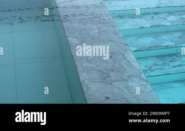 marble stair of swimming pool and wall tide under water, pan left to ...