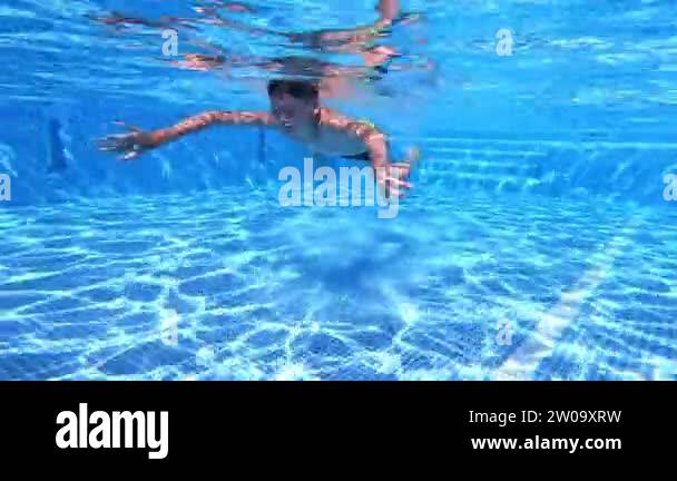 Boy swimming under the water in the swimming pool. Underwater ...