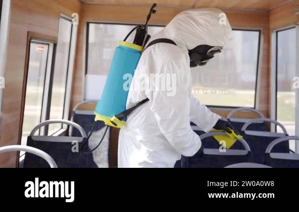 Hazmat team worker disinfects bus interior with antibacterial sanitizer ...